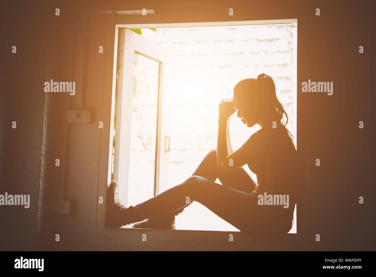 Woman sitting in an open old window Stock Photo - Alamy
