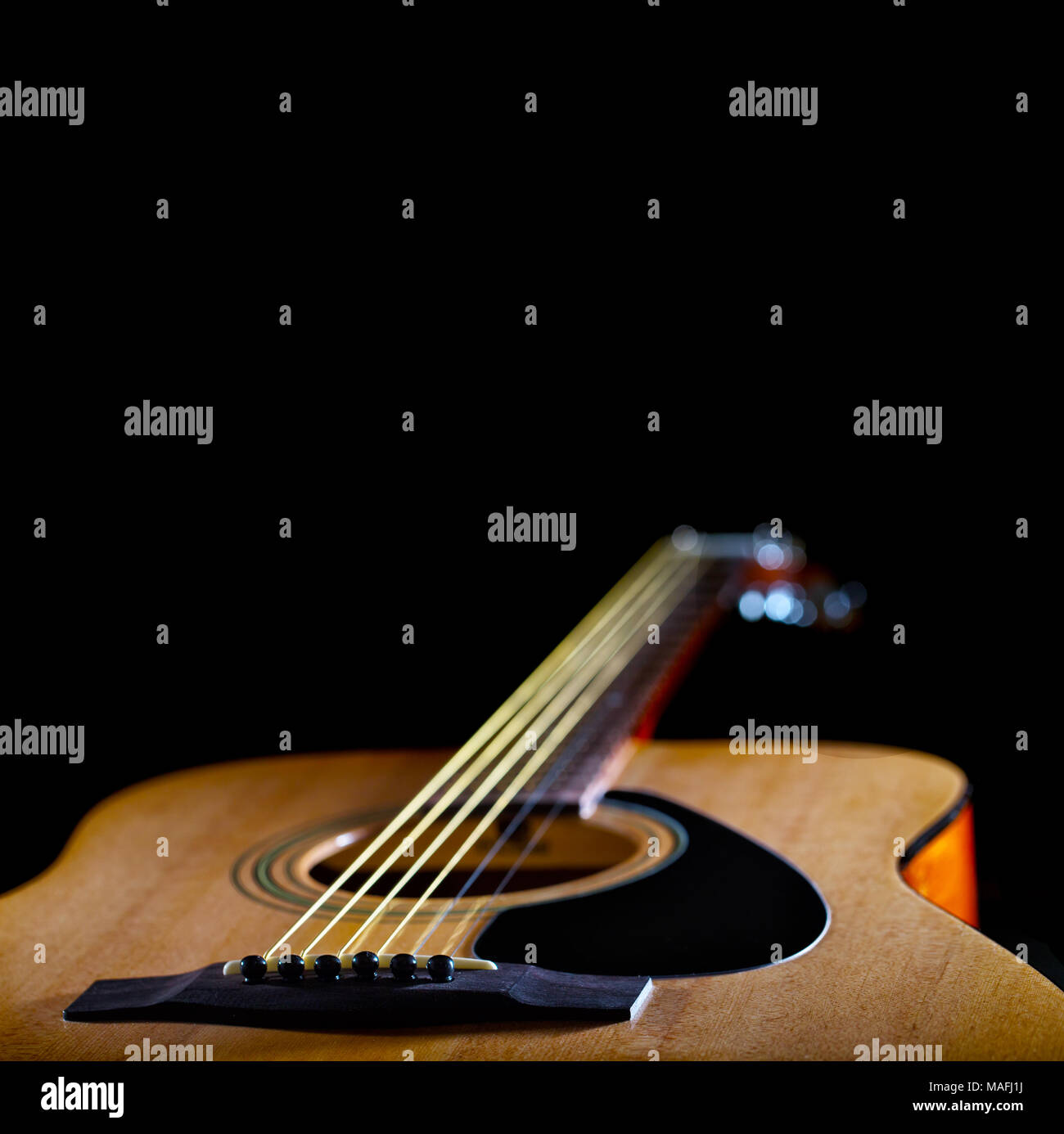 Acoustic yellow guitar isolated on black background Stock Photo - Alamy