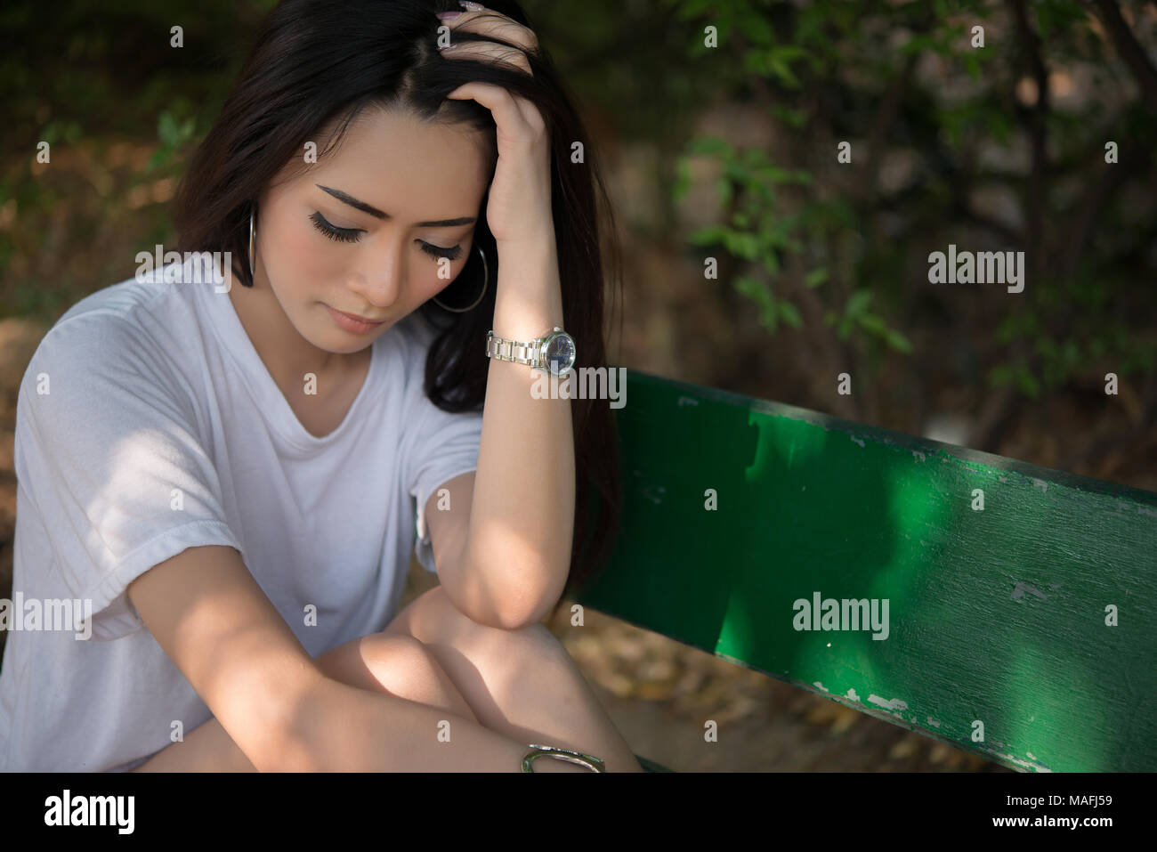 Sad loneliness woman sitting on a bench alone at park Stock Photo - Alamy