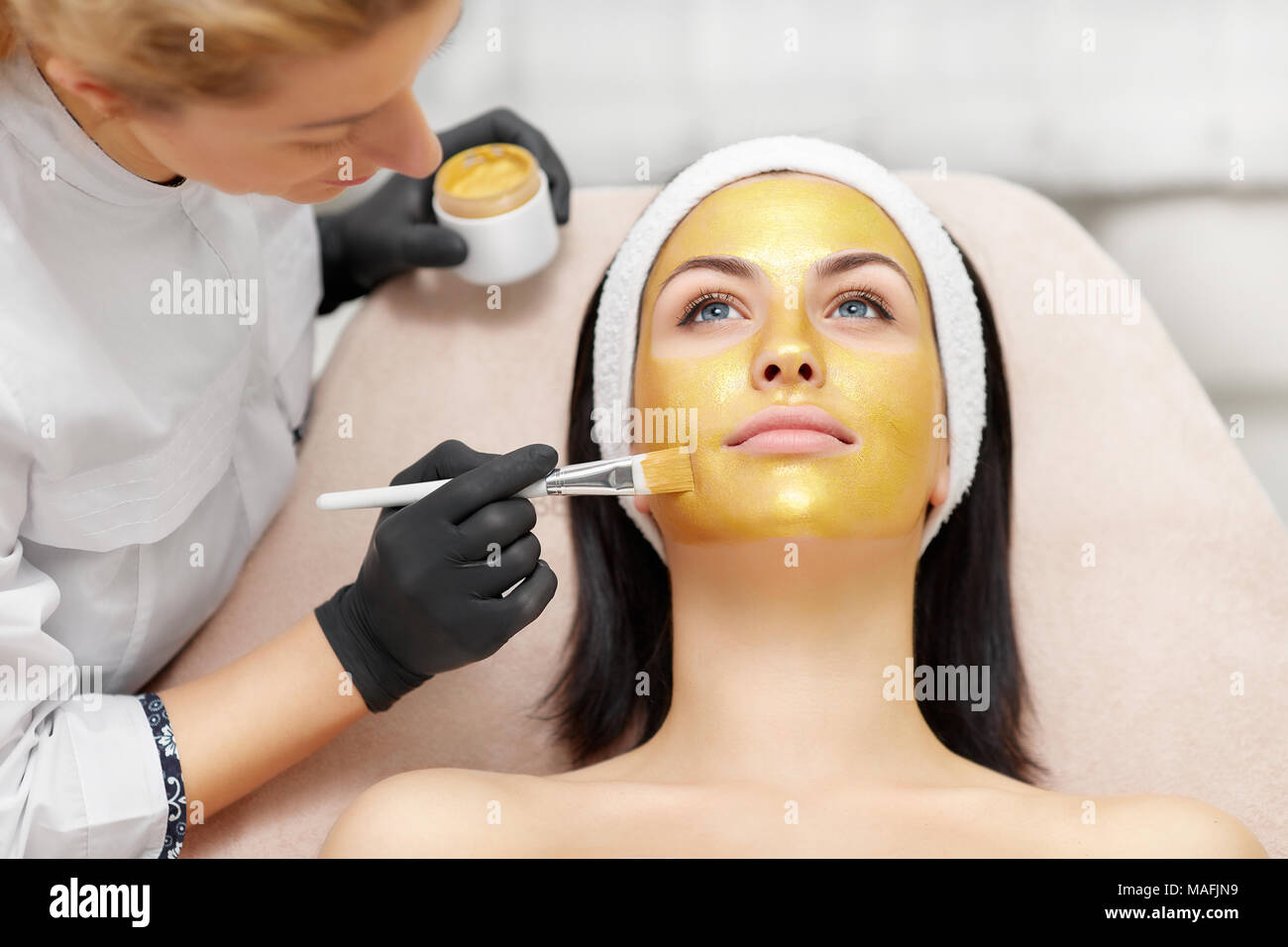 Peeling Gold Mask for Beautiful Face Skin. Cosmetologist doing beauty ...