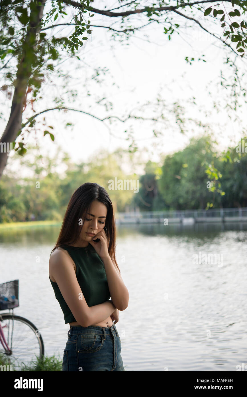 Young pretty girl was sad standing in the park she was disappointed ...