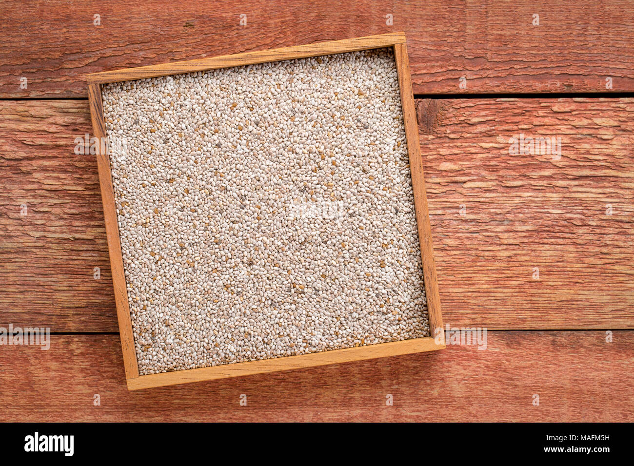 organic white chia seeds in a wooden box against weather wood ...