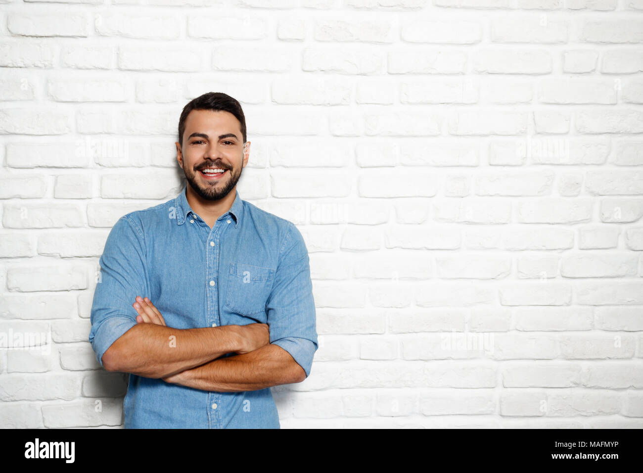 Portrait of happy Italian man smiling against white wall as background ...