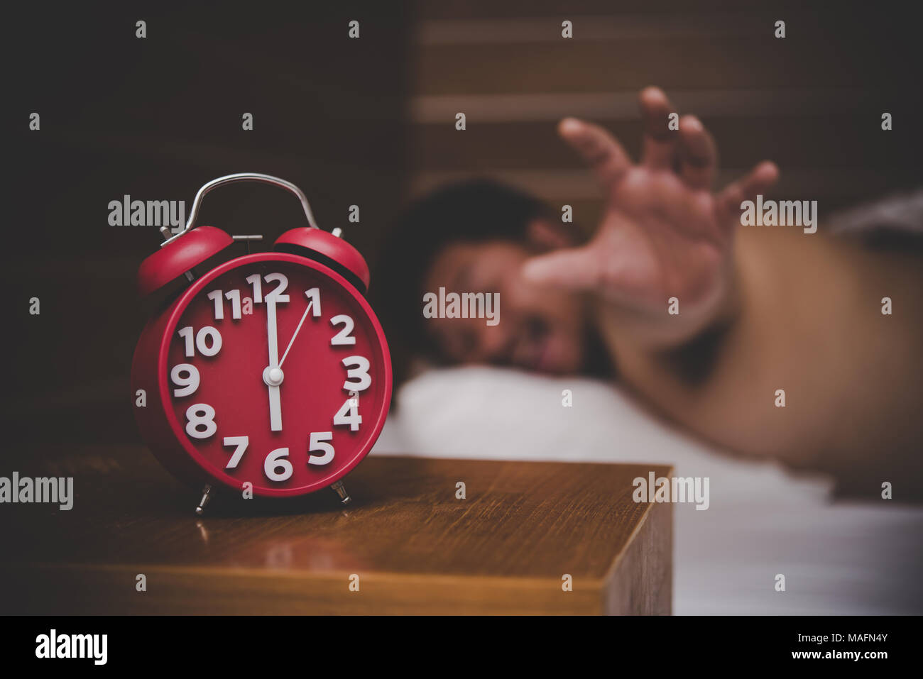 Man being awakened by an alarm clock in his bedroom Stock Photo - Alamy