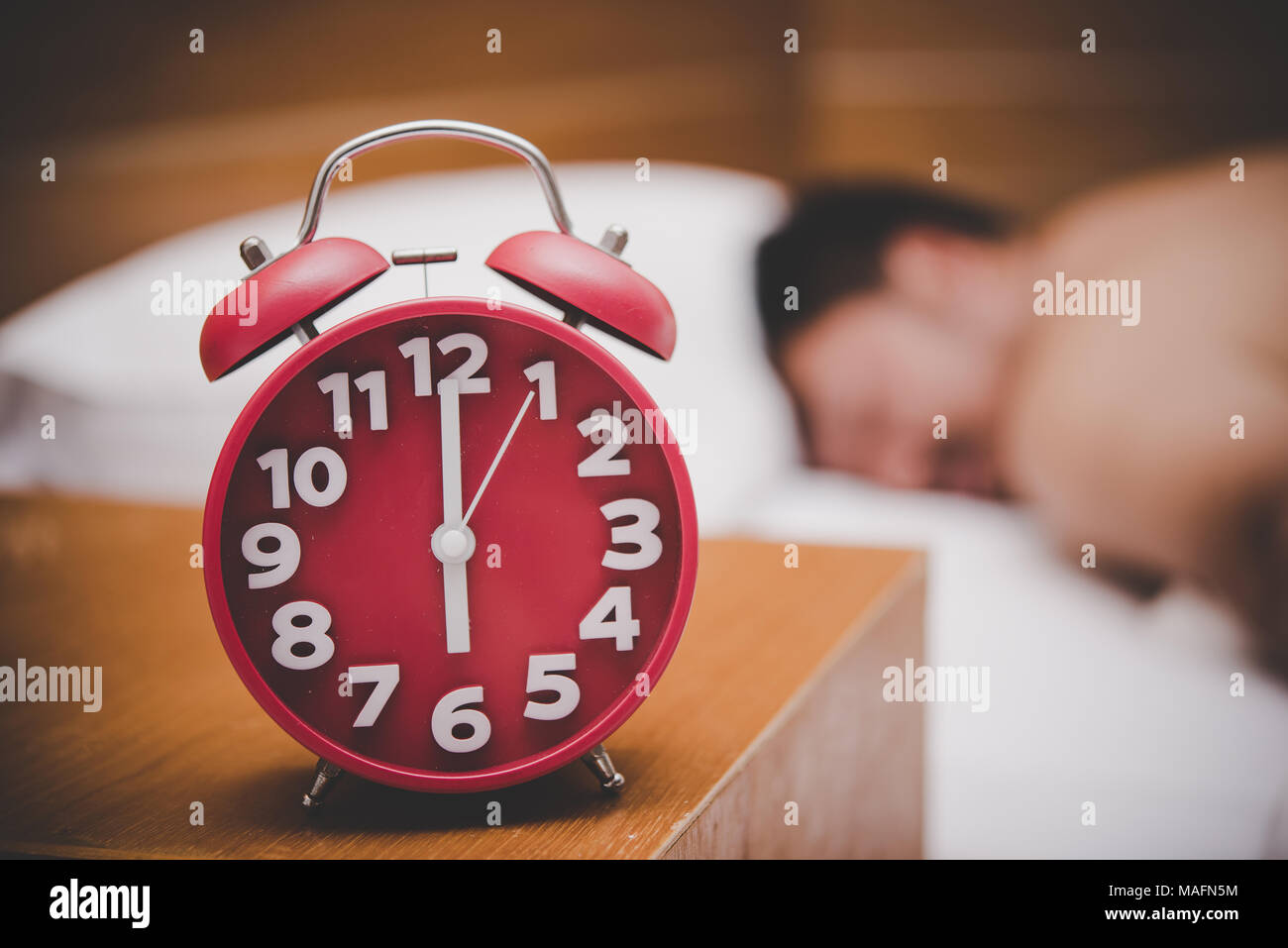 Man being awakened by an alarm clock in his bedroom Stock Photo - Alamy