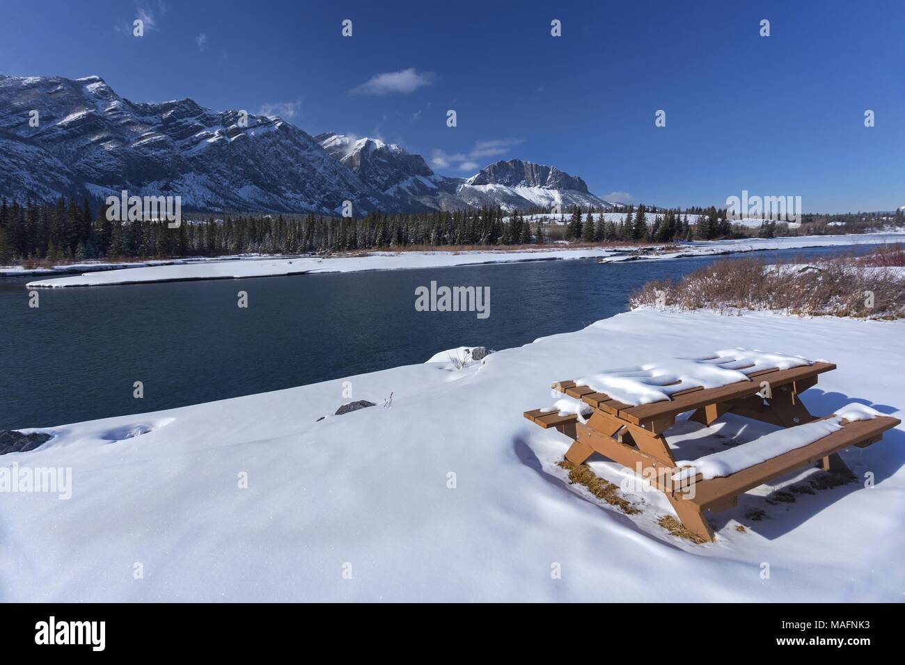 Picnic Park Table covered by snow and Bow River in Whitefish Picnic ...