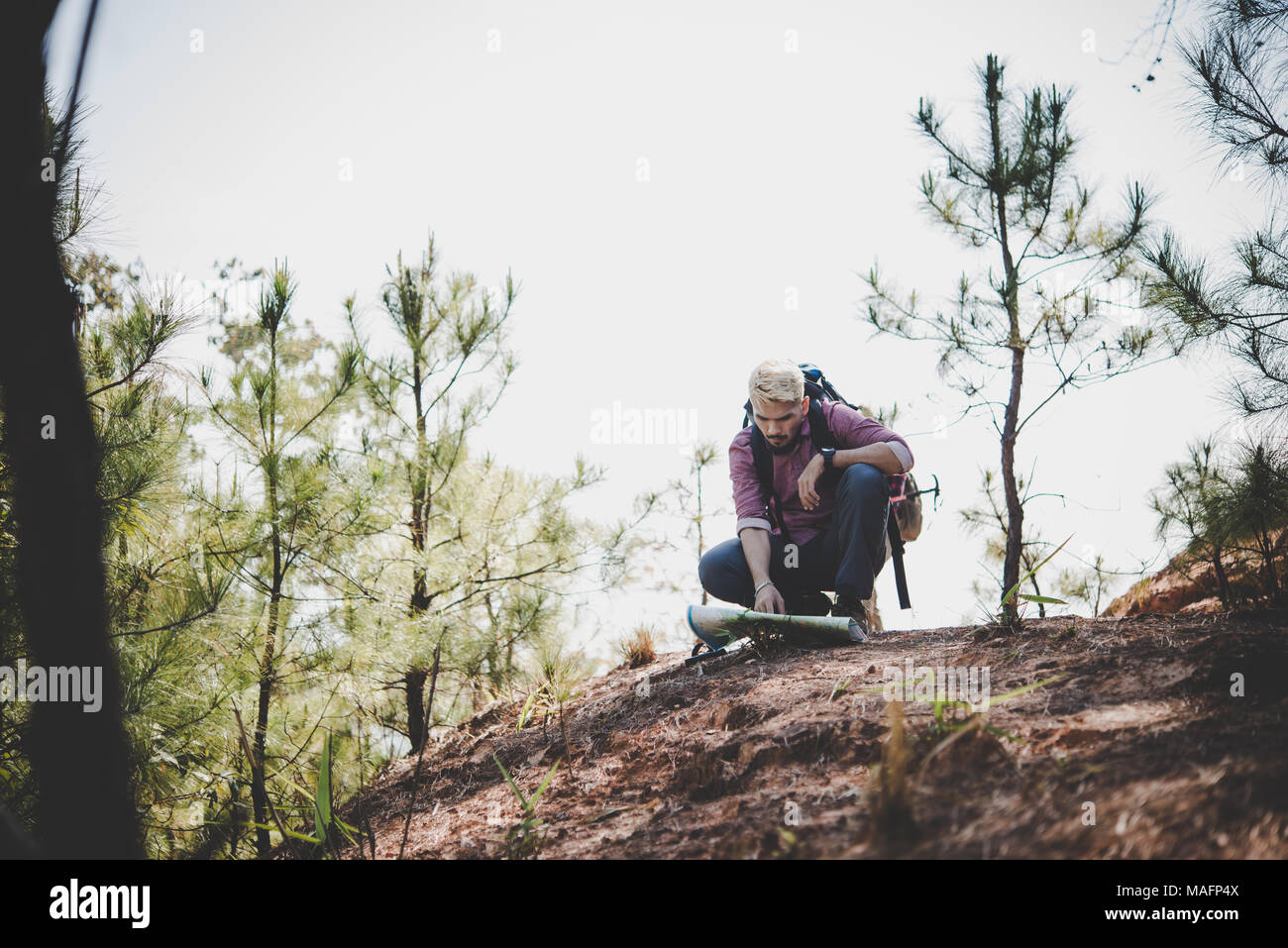 Hiker with map and big traveling backpack traveling to the mountain ...
