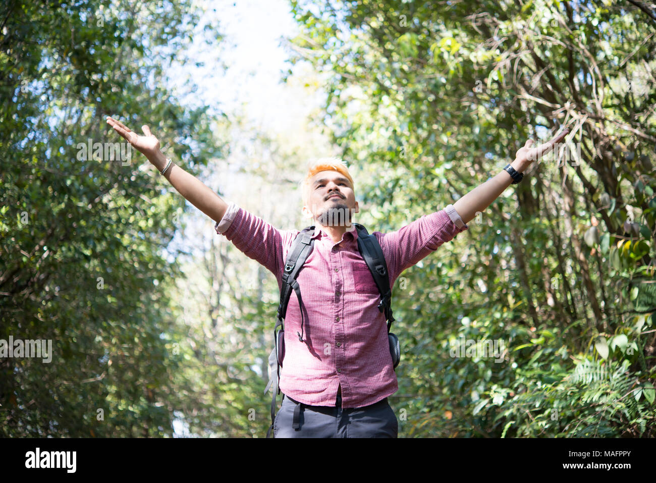 Active young man hiker open arms enjoy with nature while walking though ...