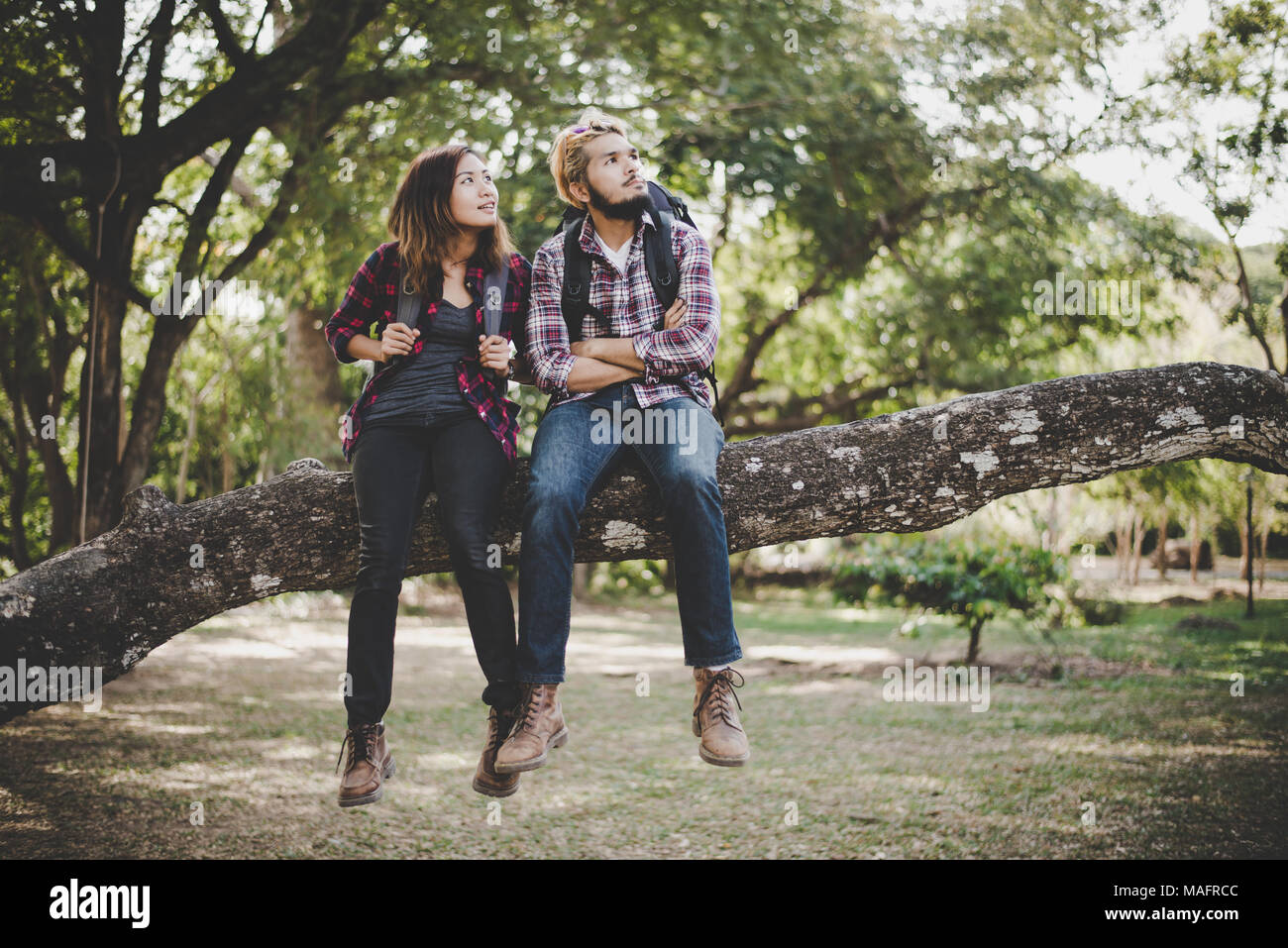 Young couple sitting on tree branch hi-res stock photography and images ...
