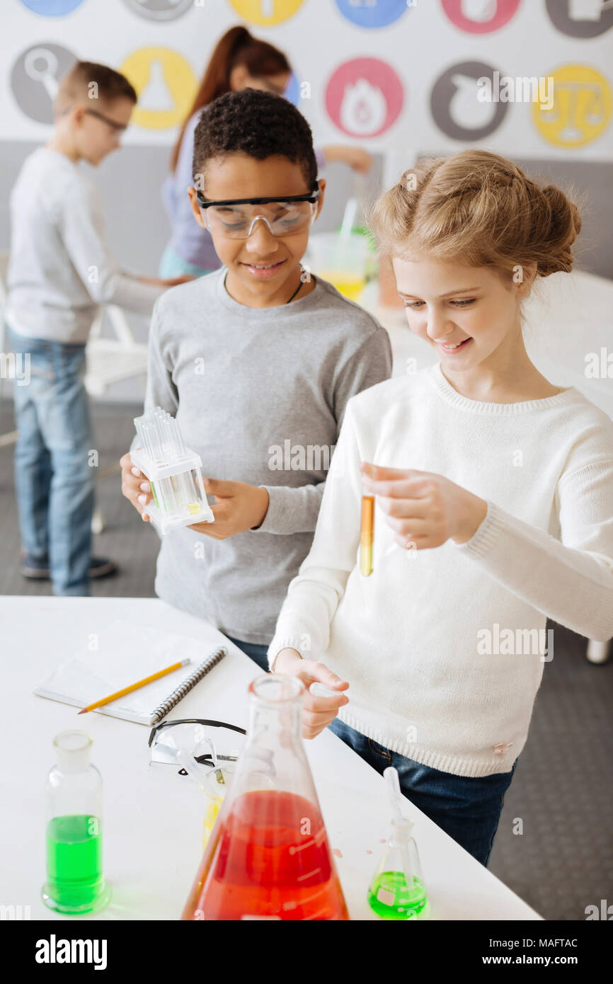 Cheerful boy watching his classmate conduct chemical experiment Stock ...