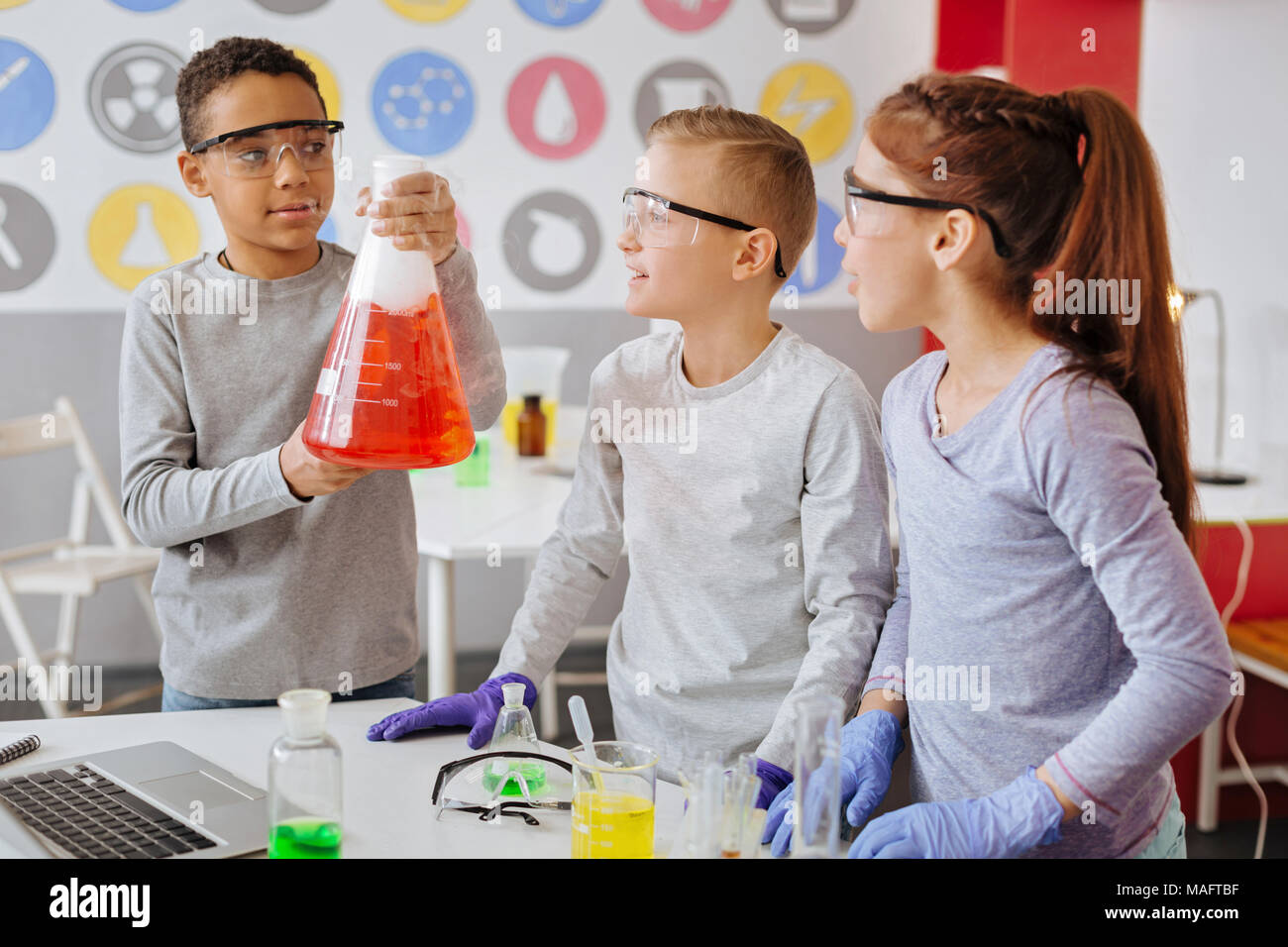 Pleasant boy demonstrating chemical experiment to classmates Stock ...