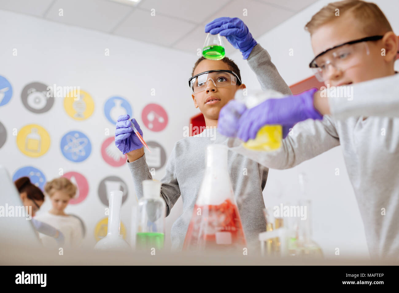 Two best friends being busy with mixing chemicals during class Stock ...