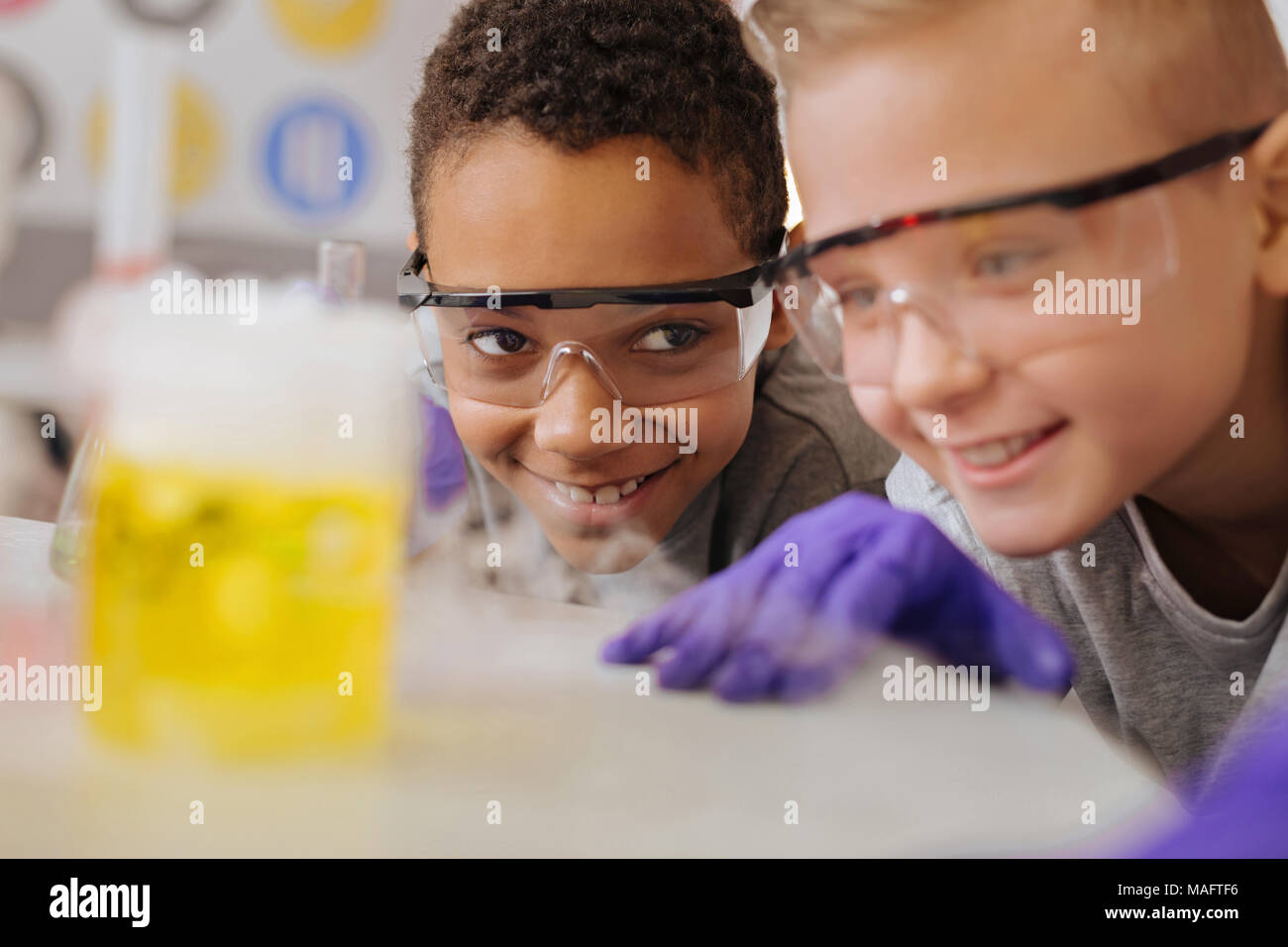 Close up of two classmates observing chemical reaction Stock Photo - Alamy