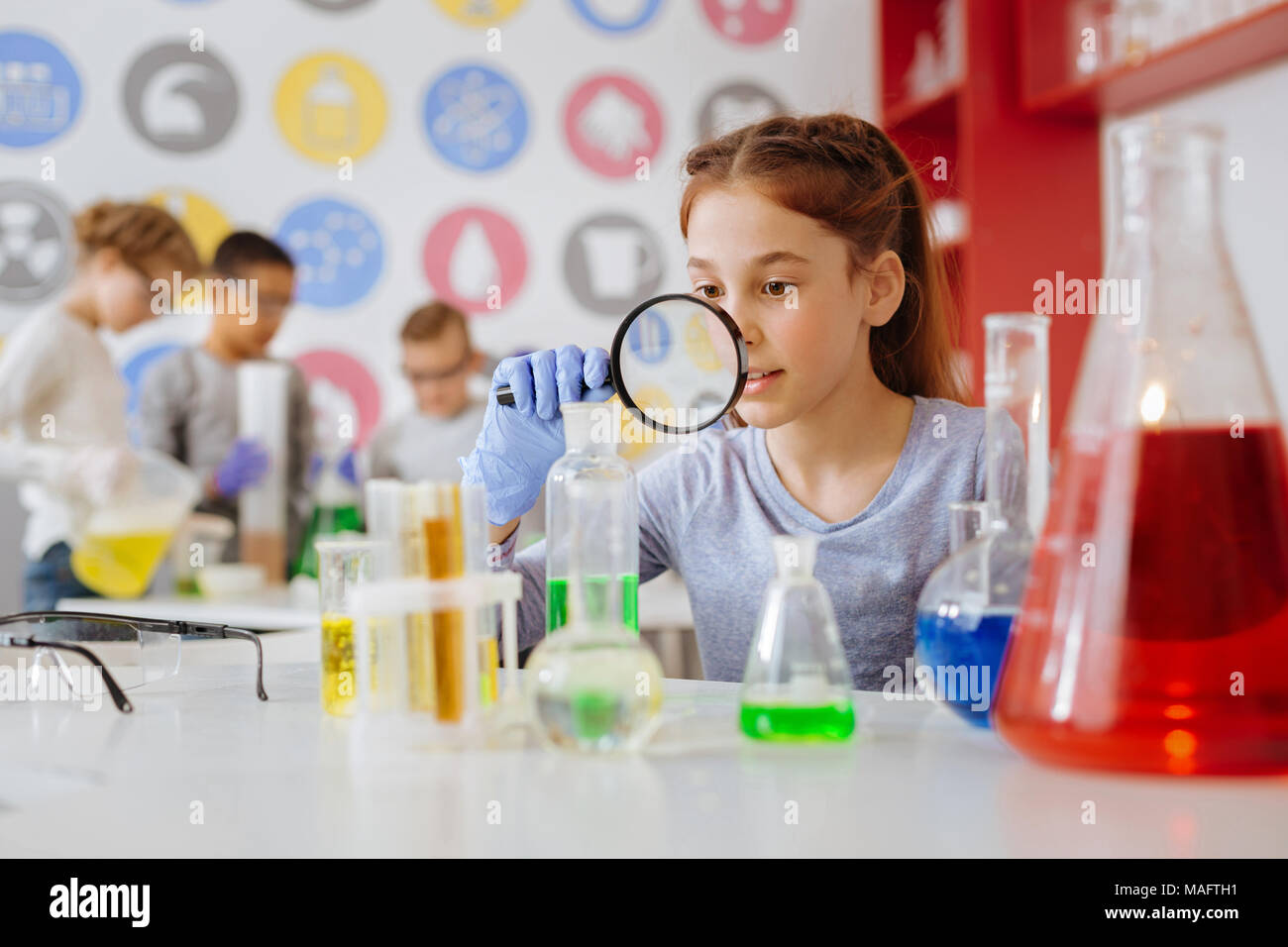 Charming girl checking content of chemical flask in lab Stock Photo - Alamy