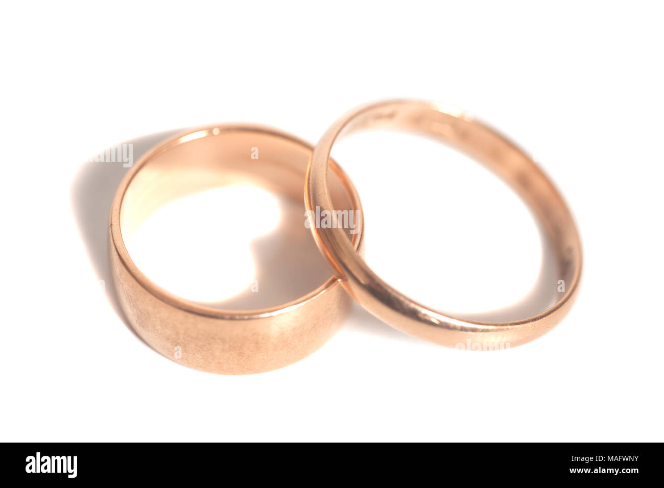 Two golden wedding rings on white background Stock Photo - Alamy