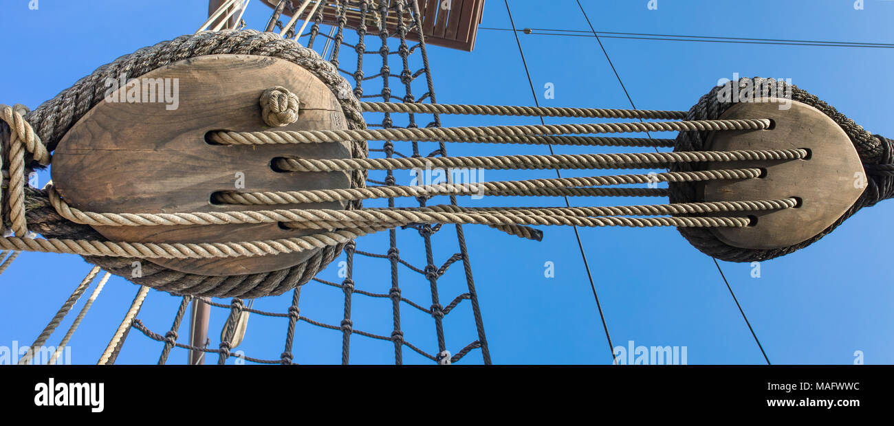 Ropes, pulley, shroud - parts of an old ship, sailboat. Blue sky in the ...
