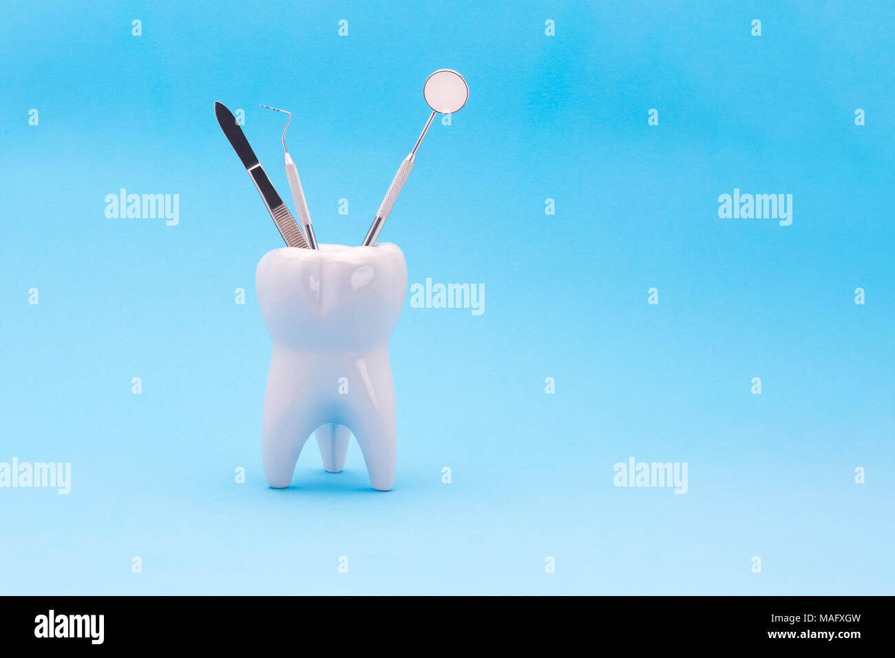 tooth model in the form of a stand with dental instruments inside. The ...