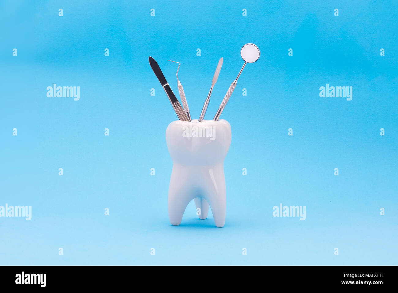 tooth model in the form of a stand with dental instruments inside. The ...