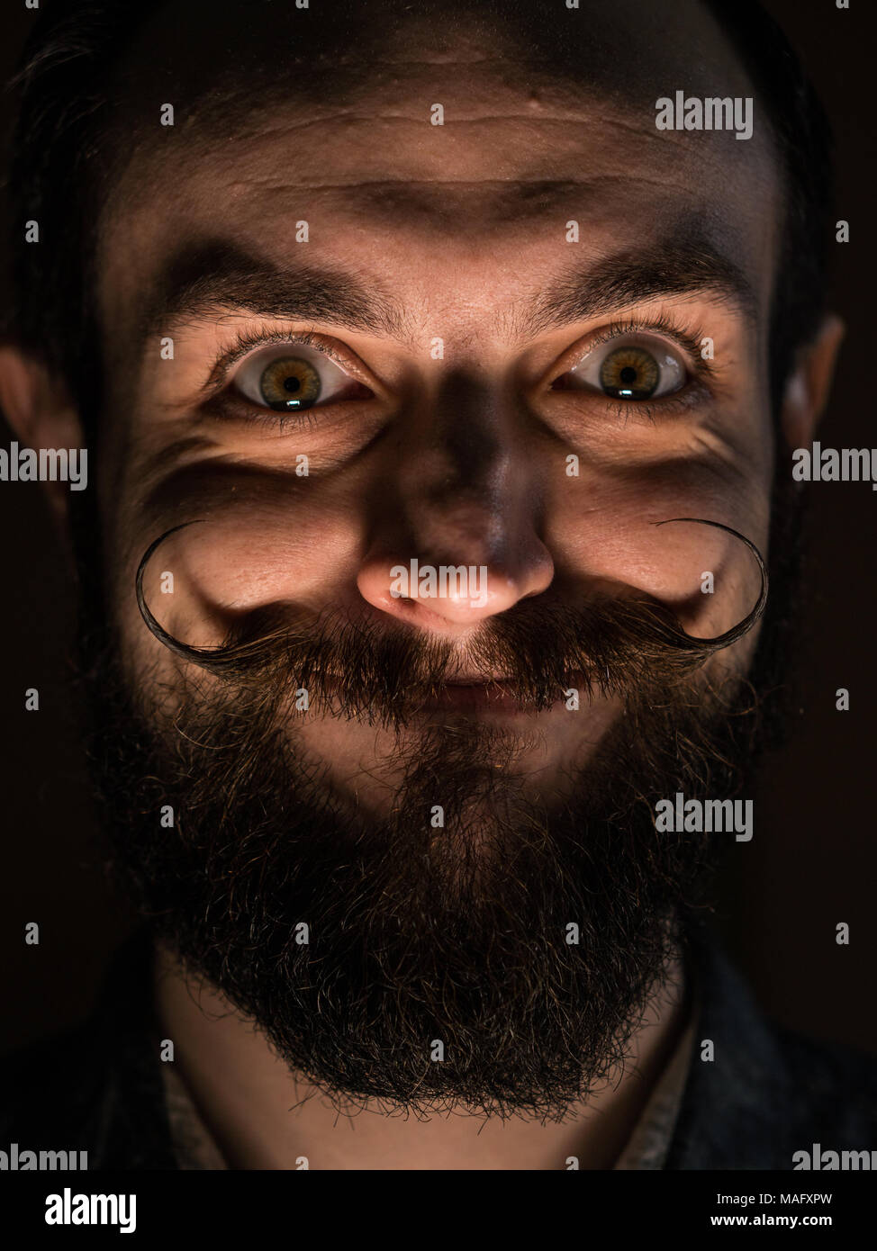 Inventor Hipster with Beard and Mustages in the Dark Room. Smiling ...