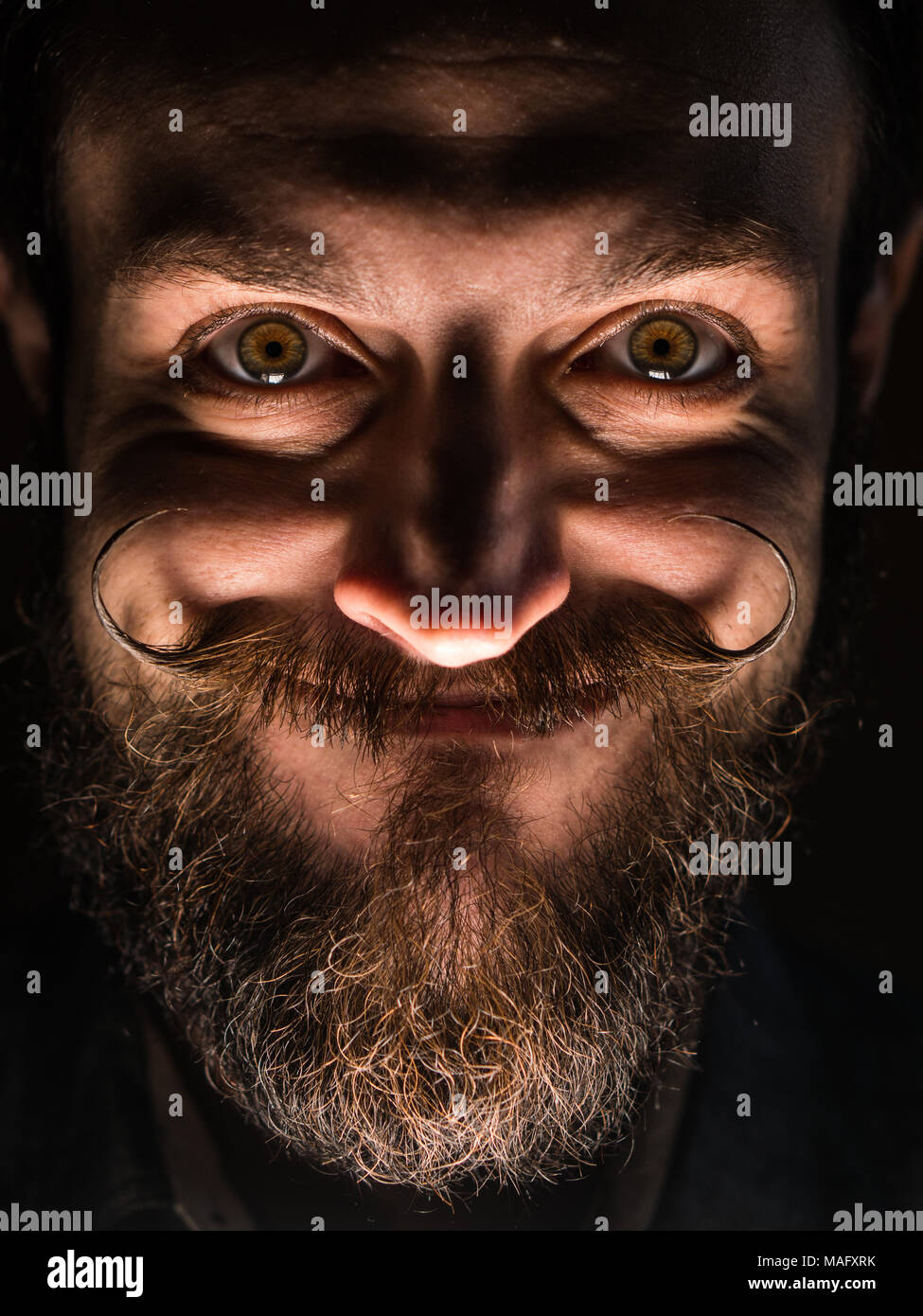 Inventor Hipster with Beard and Mustages in the Dark Room. Smiling ...