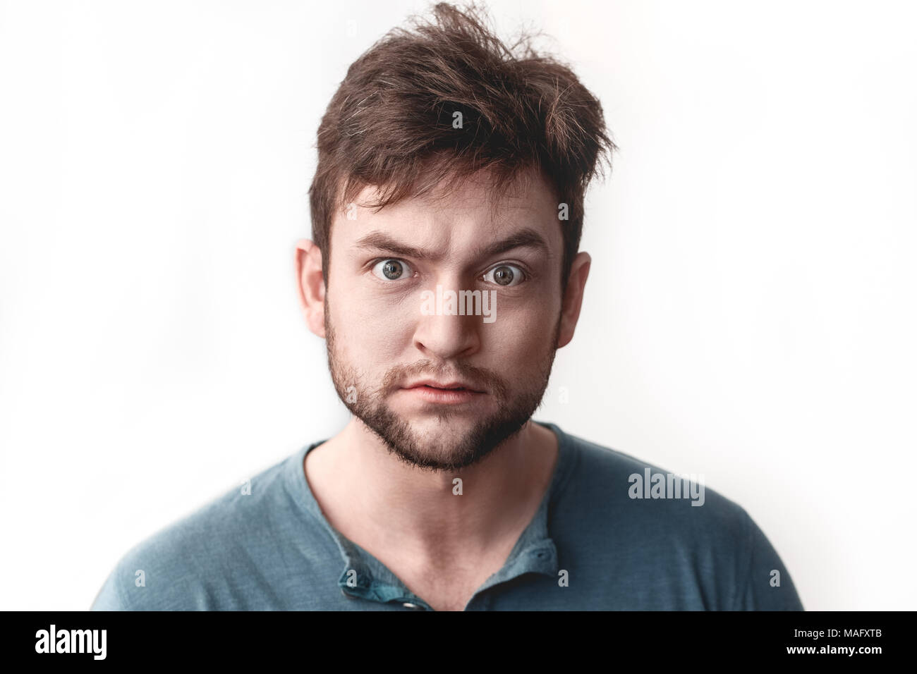 Man isolated on white wall facial expressions close-up looking camera ...