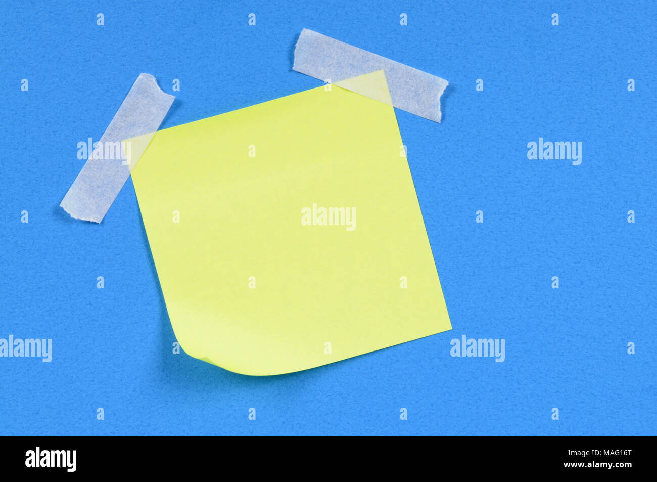 Yellow sticky note taped to blue paper Stock Photo - Alamy