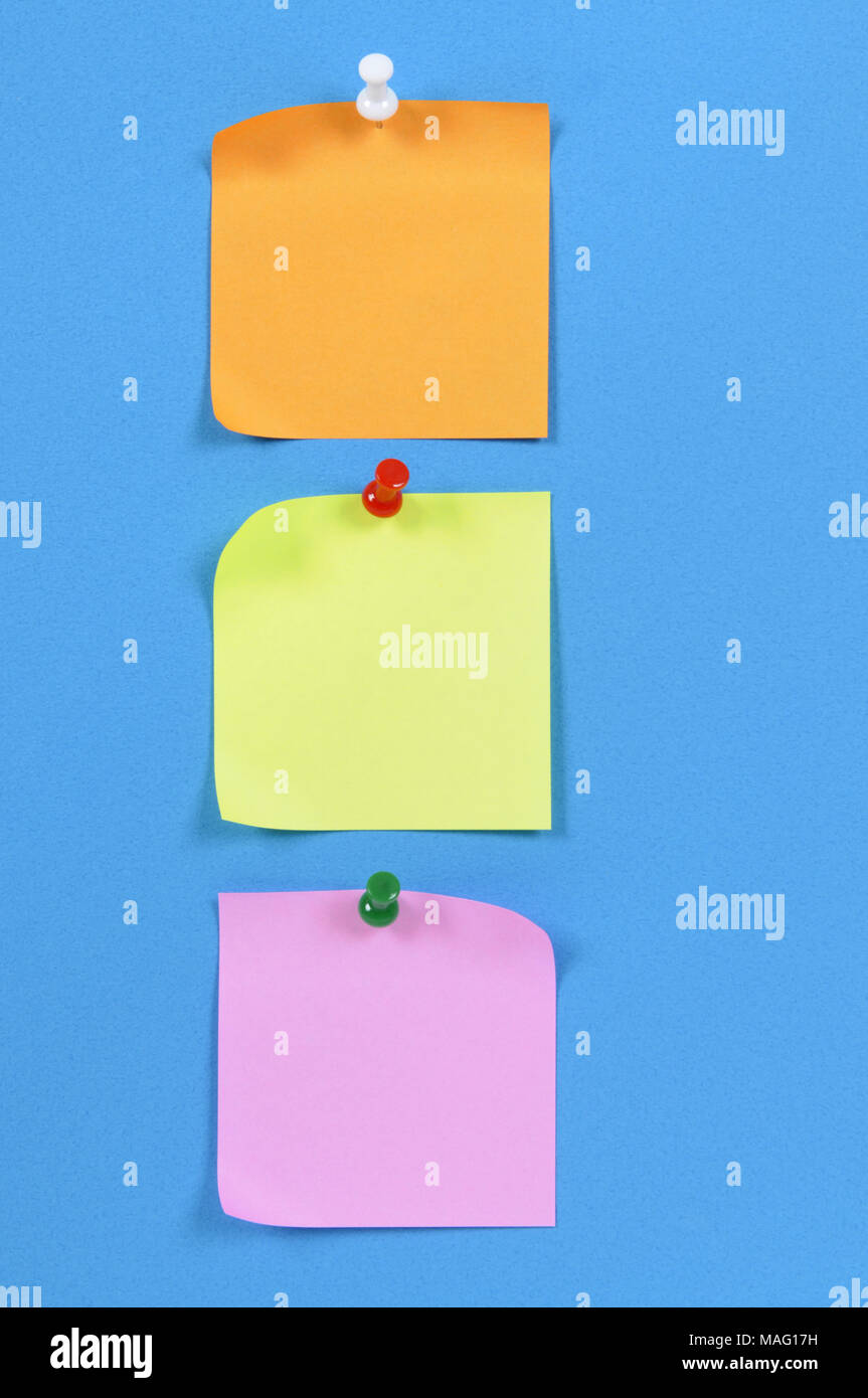 Office sticky notes pinned to blue paper Stock Photo - Alamy