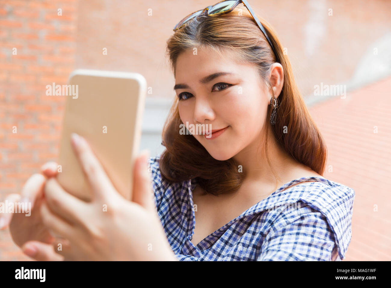 Attractive Happy Young Asian Woman Taking Her Selfie Outdoor With Her Cellphone To Share On