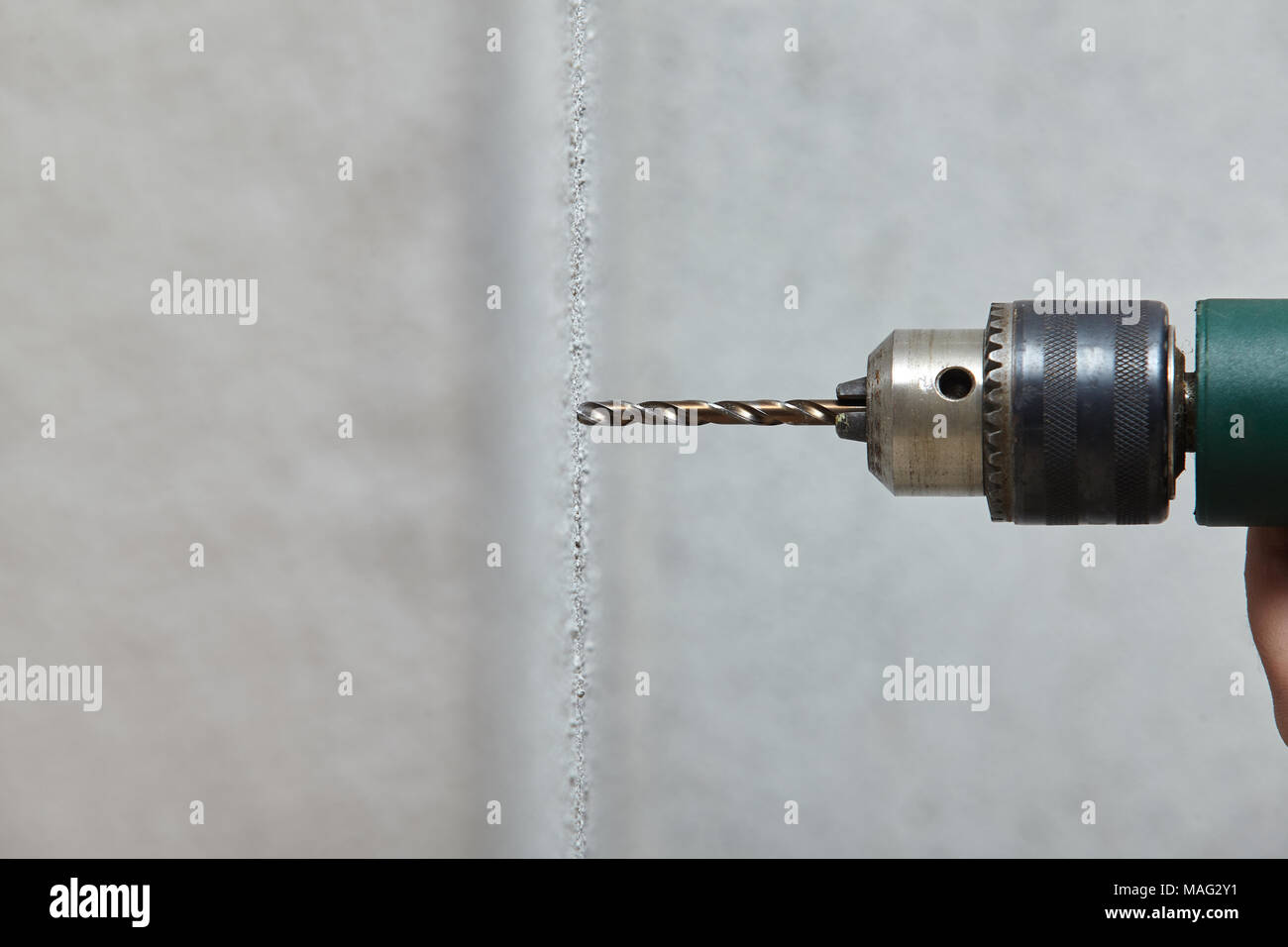 Worker drilling a hole into the wall with an electric drill Stock Photo ...