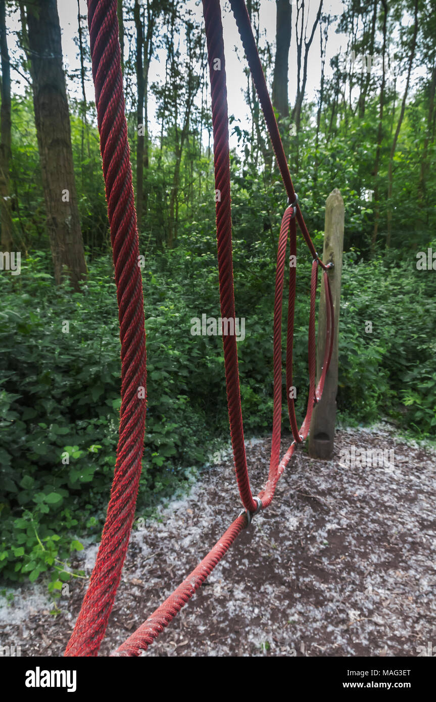 perspective of red rope suspended from a wooden pole placed in the ...