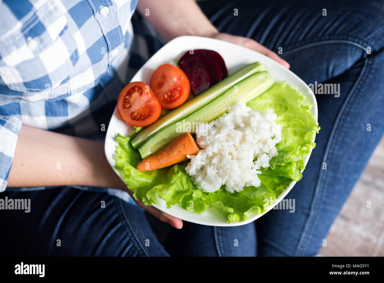 Girl with a plate of vegetables in hands Stock Photo - Alamy