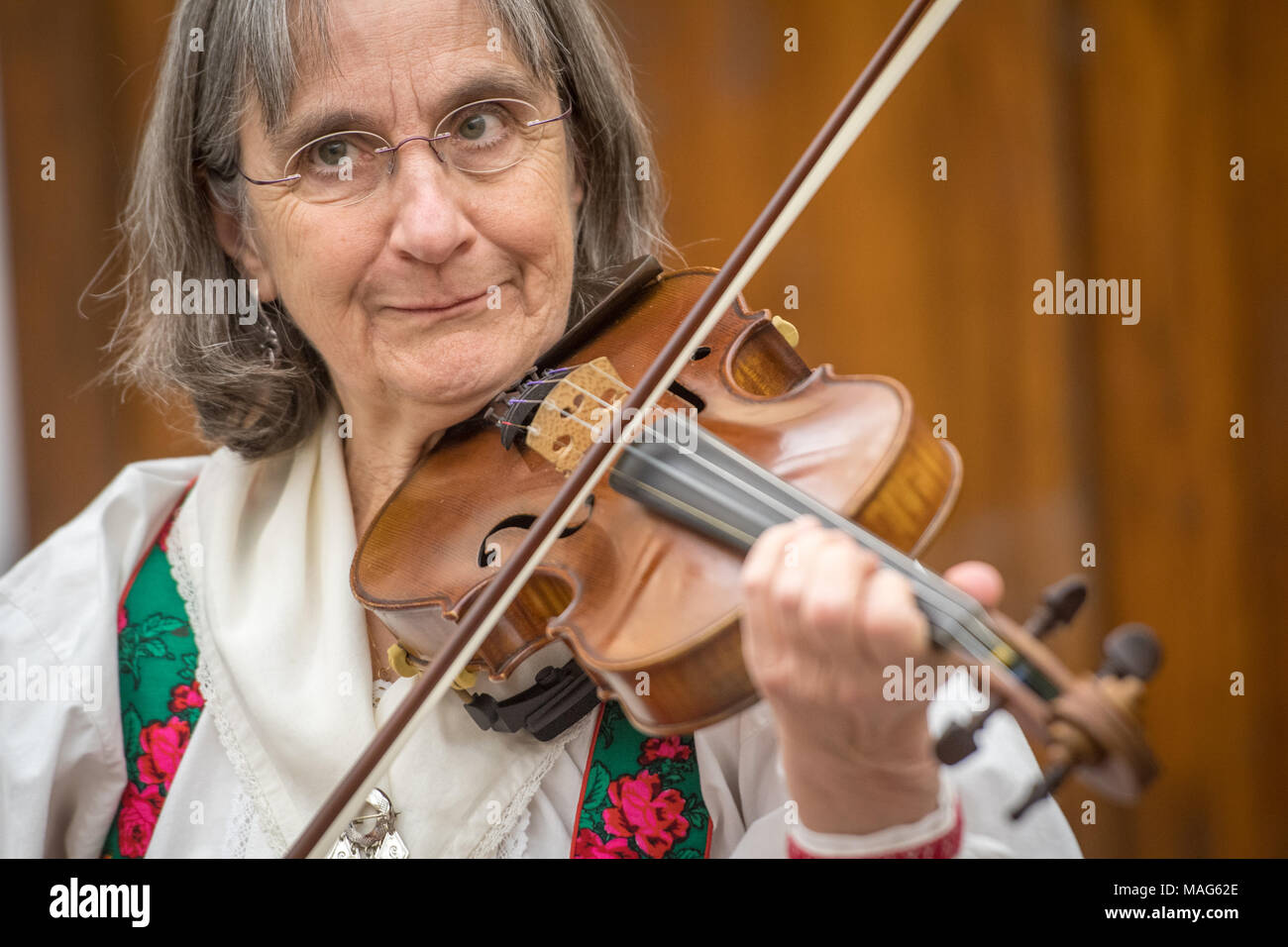 Woman plays a song on the Swedish Fiddle in a traditional Scandinavian ...