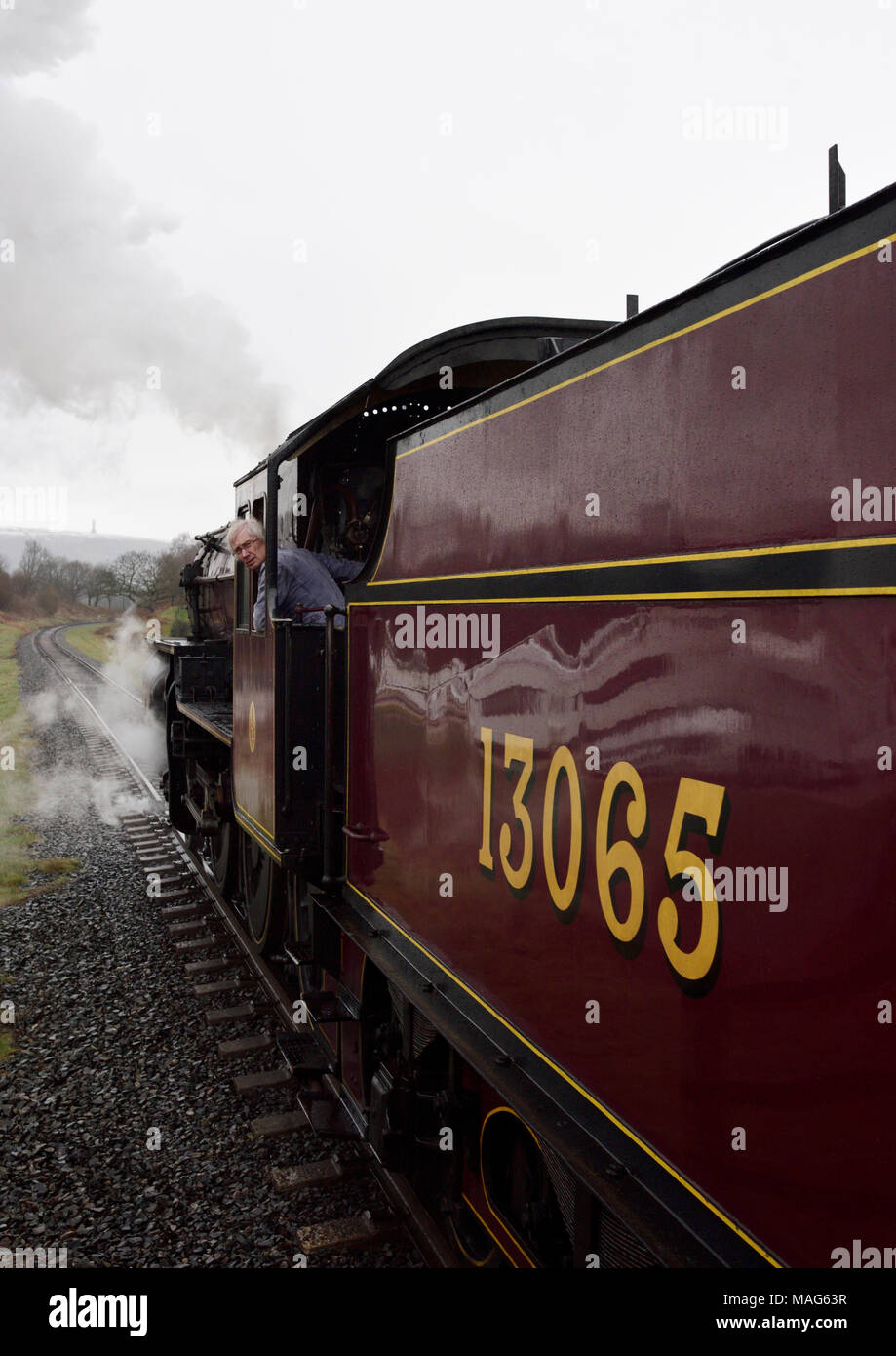 Steam locomotive and tender with the driver looking back towards the ...