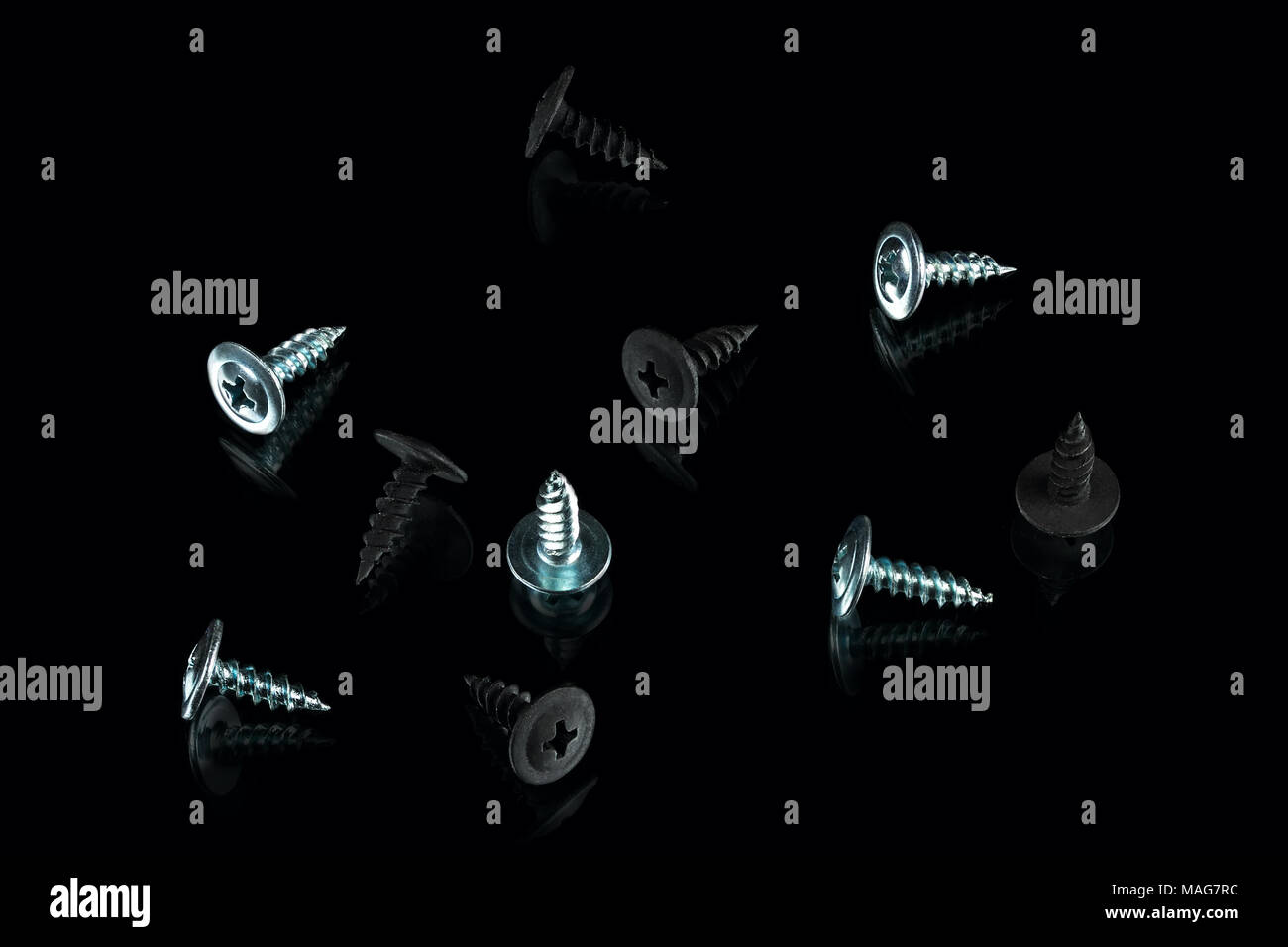 silver chrom and anodized screws on black background Stock Photo - Alamy