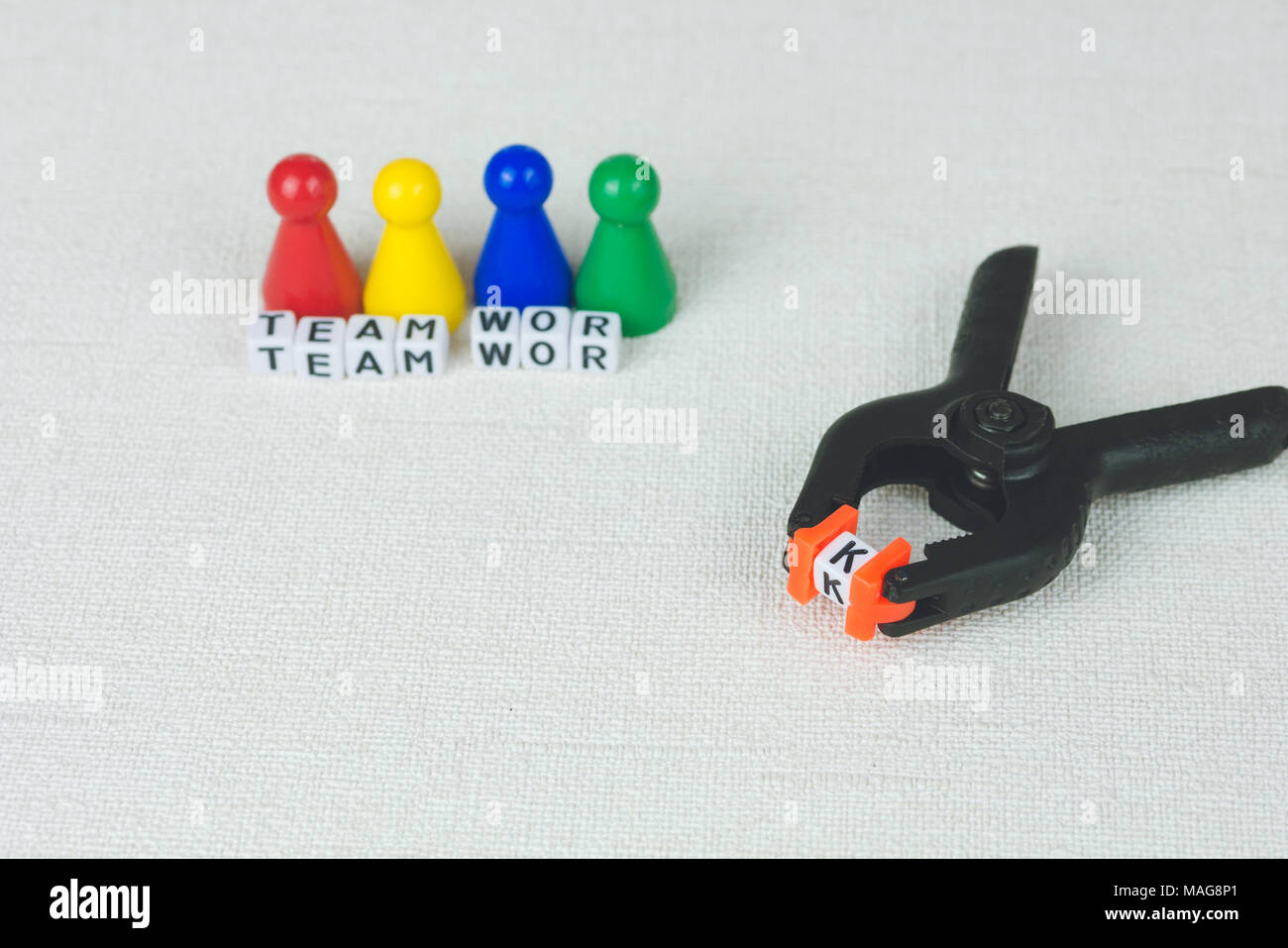 Team work concept - Figures in the line and an clamp tool as symbol for ...
