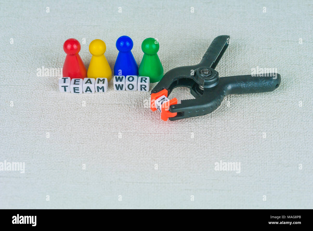 Team work concept - Figures in the line and an clamp tool as symbol for ...