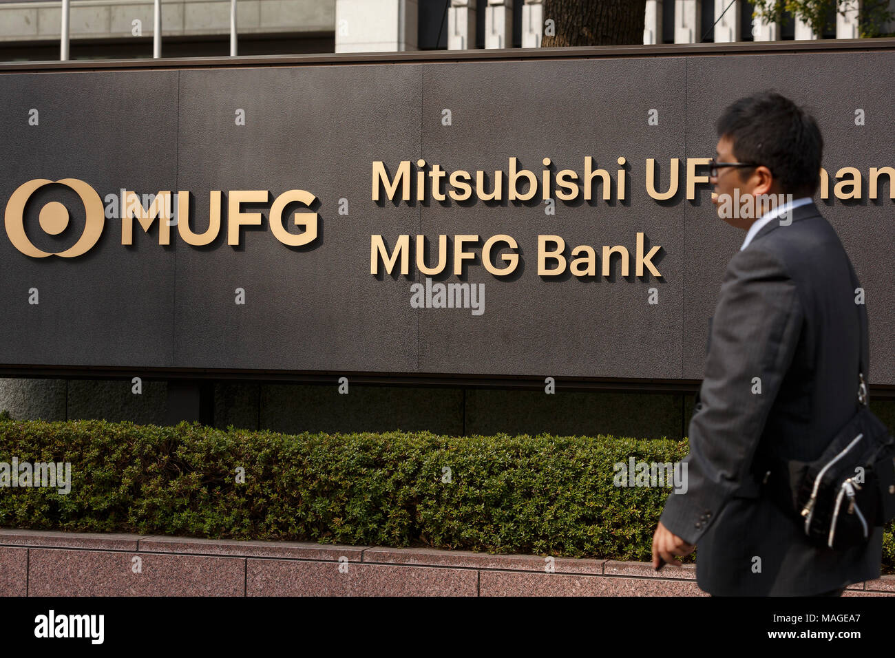 A man walks past a new signboard of MUFG on display outside its building on April 2, 2018, Tokyo ...