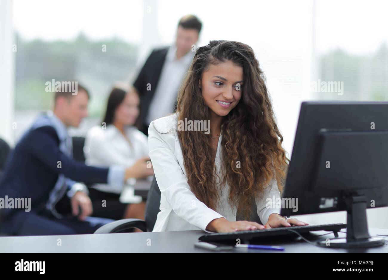 Manager woman sitting behind a Desk Stock Photo - Alamy