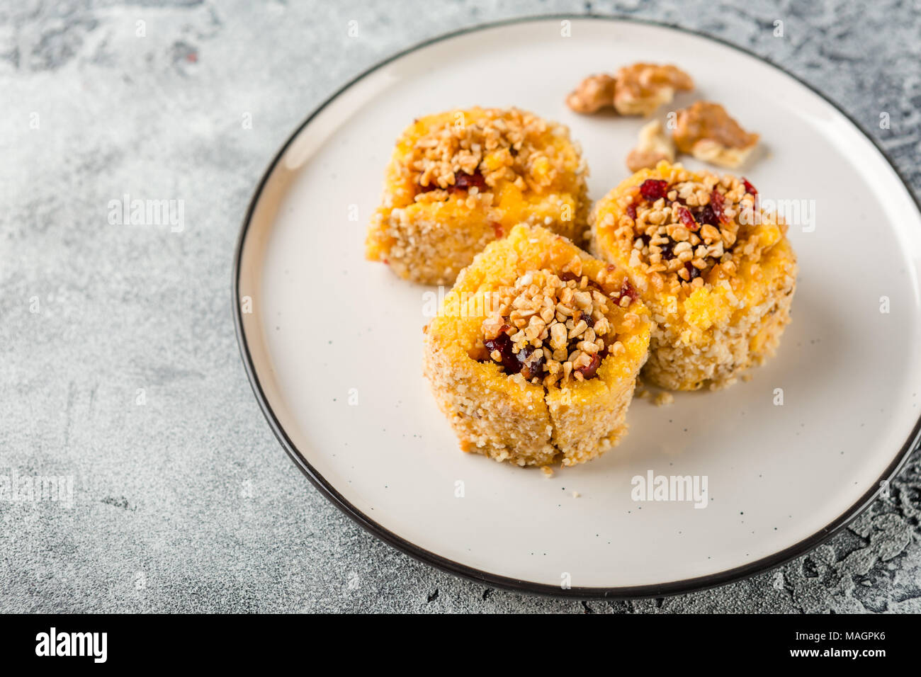Sweet Rolls of Polenta with dried fruits and nuts on a plate Stock ...