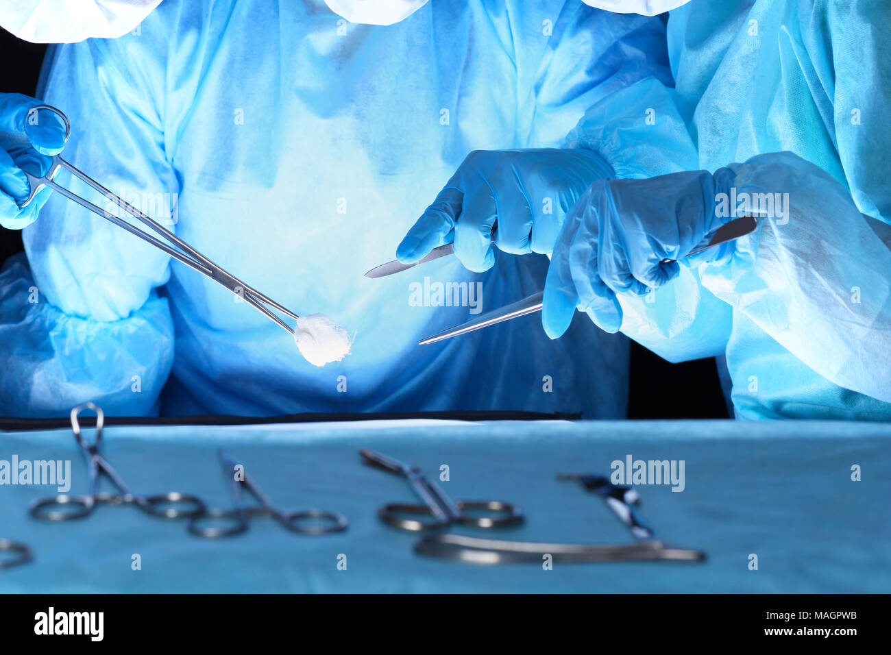 Closeup of surgeons performing operation. Focus on professional tools ...