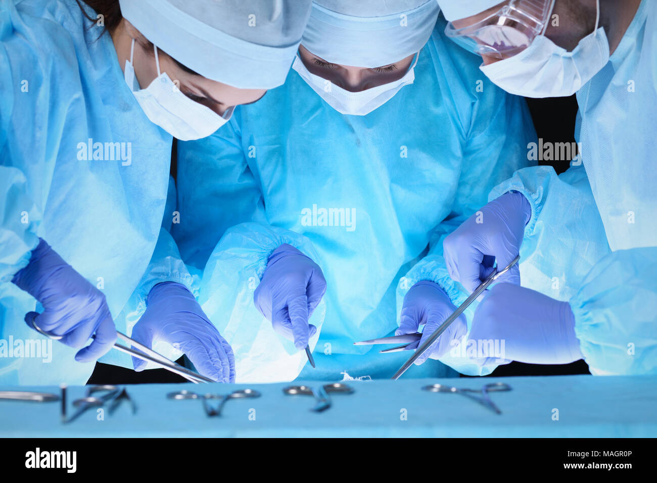 Group of surgeons at work while operating at hospital. Health care and ...