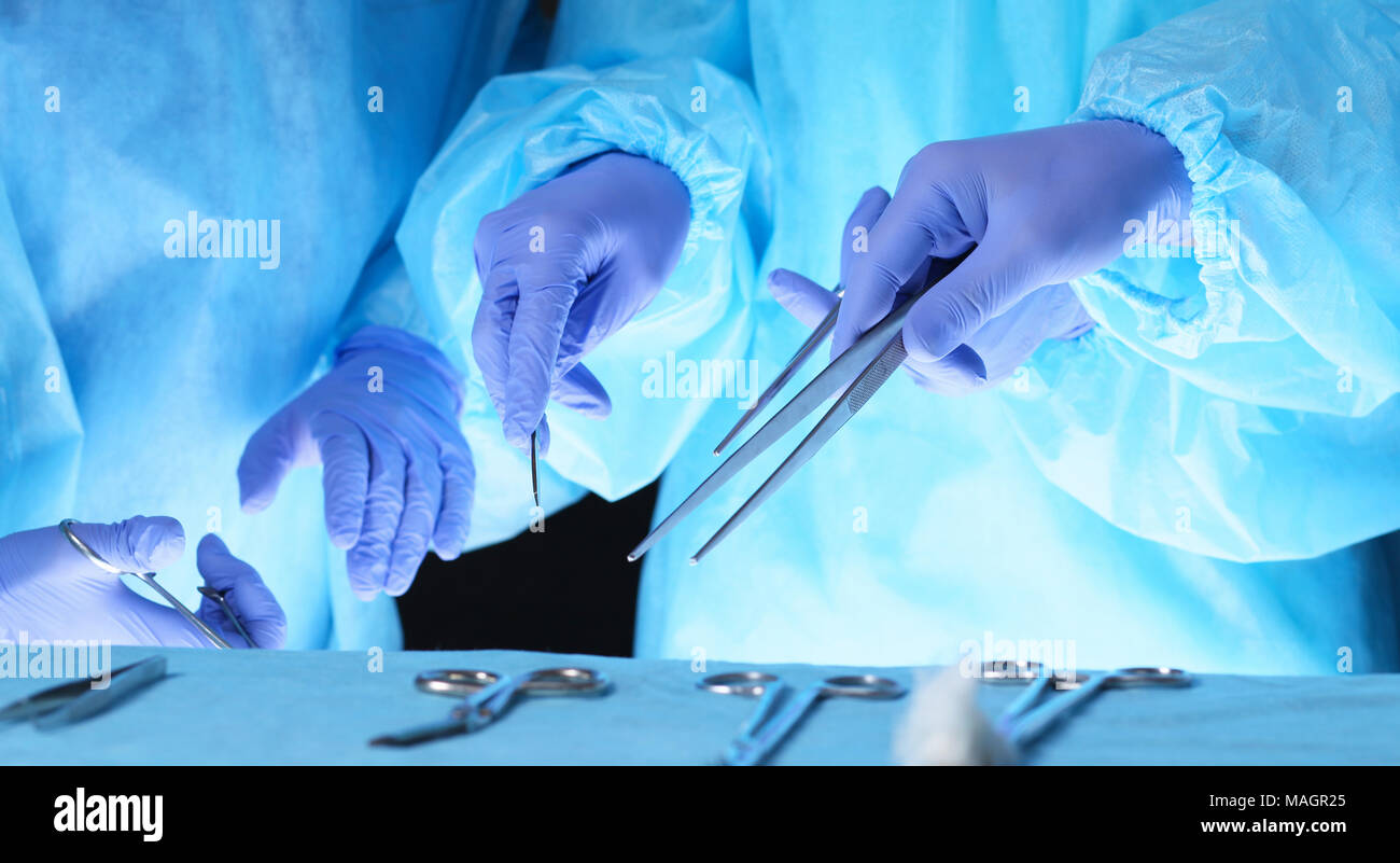Group of surgeons at work while operating at hospital, close-up of ...
