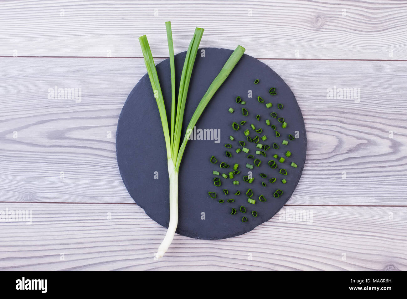 Whole and chopped green onion, top view. Fresh spring onion on round ...