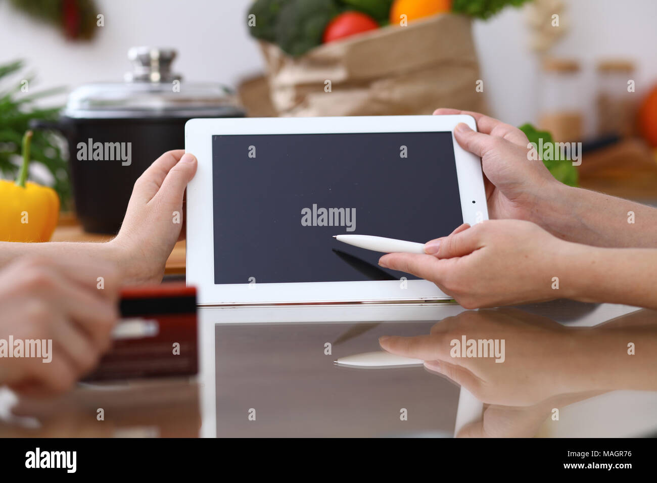 Closeup of human hands cooking in kitchen. Women discuss a menu using ...