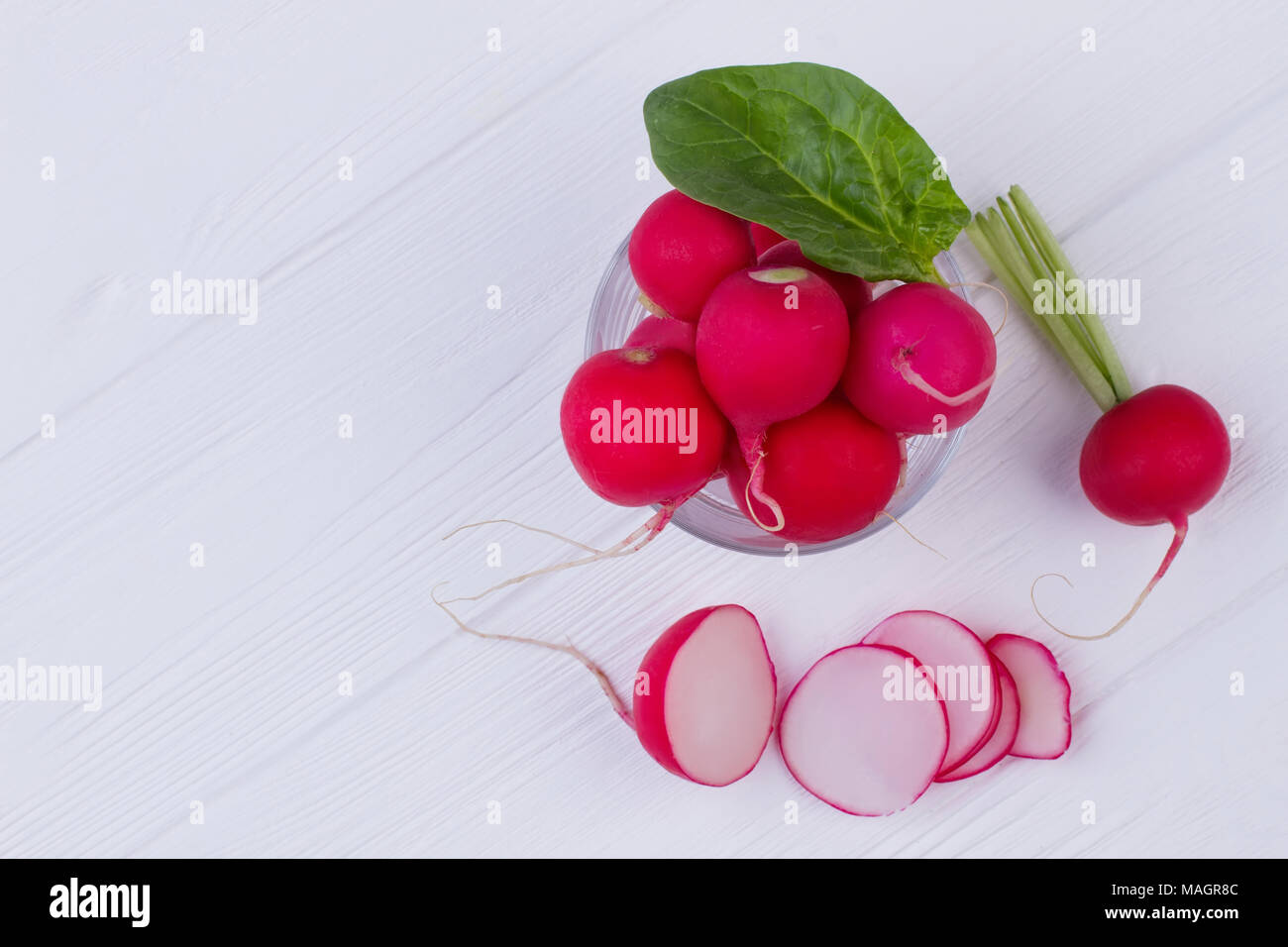 Fresh radishes on white wood, top view. Red radishes with green basil ...
