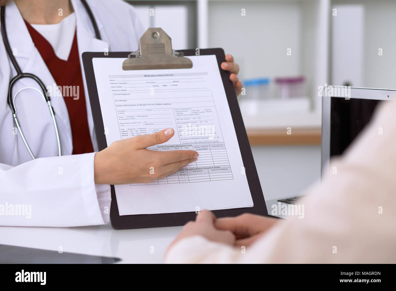 Close up of a female doctor pointing into an application form while ...