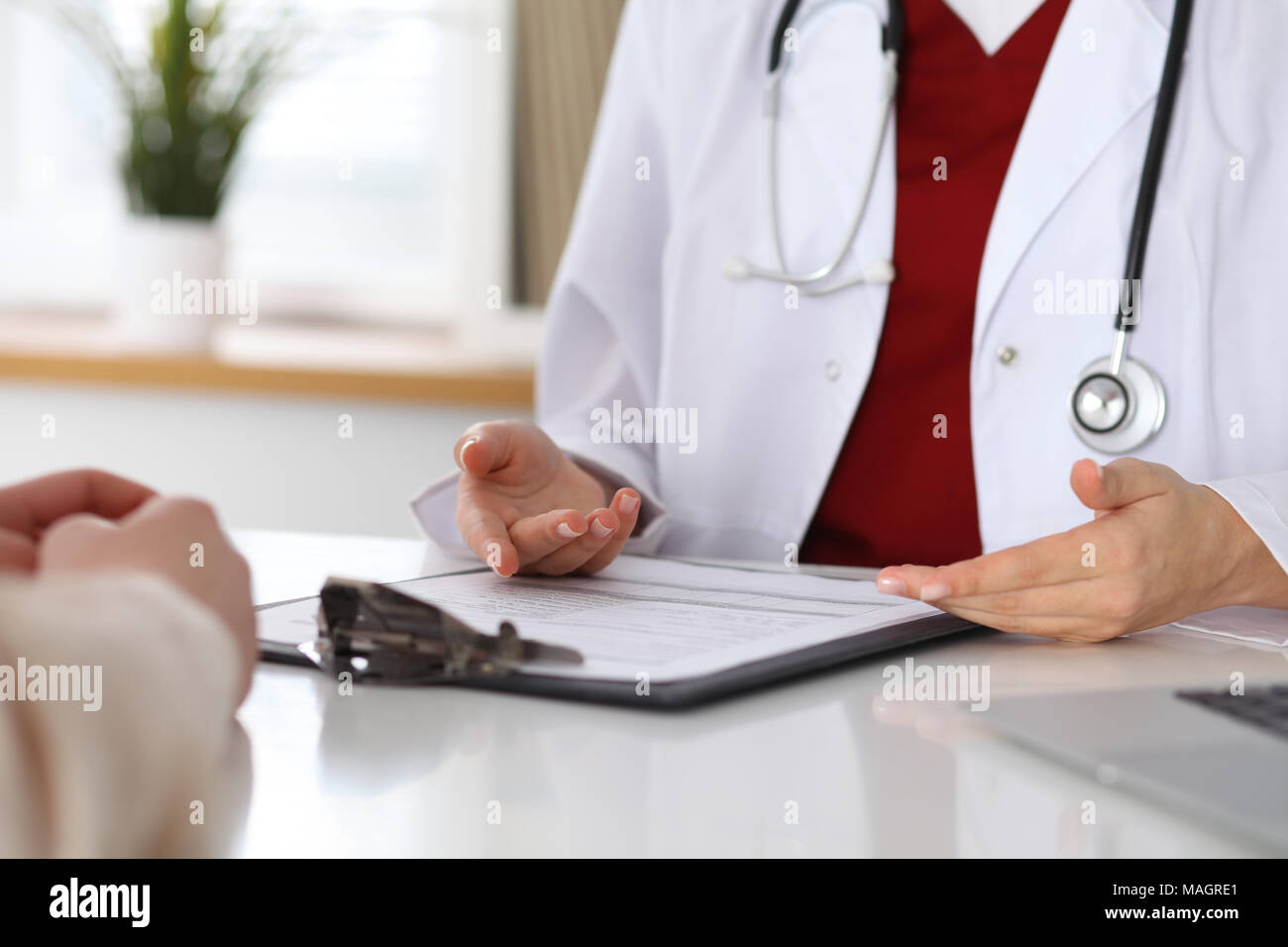 Close up of a doctor and patient hands while discussing medical records ...