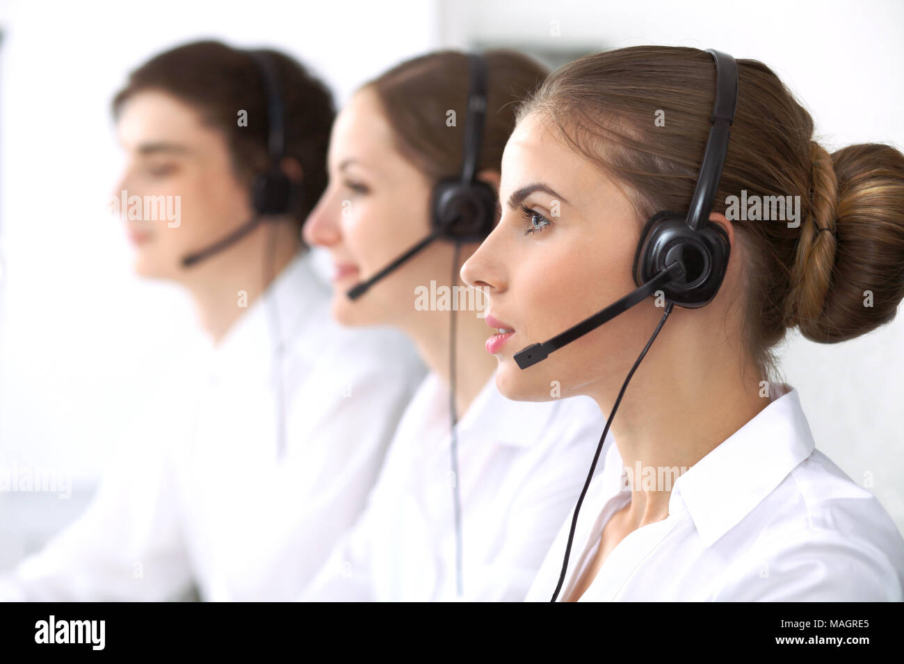 Call center. Focus on beautiful woman in headset Stock Photo - Alamy