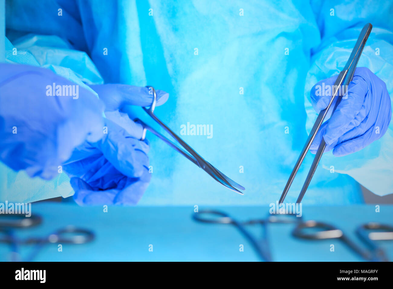 Close-up of of surgeons hands at work in operating theater toned in ...