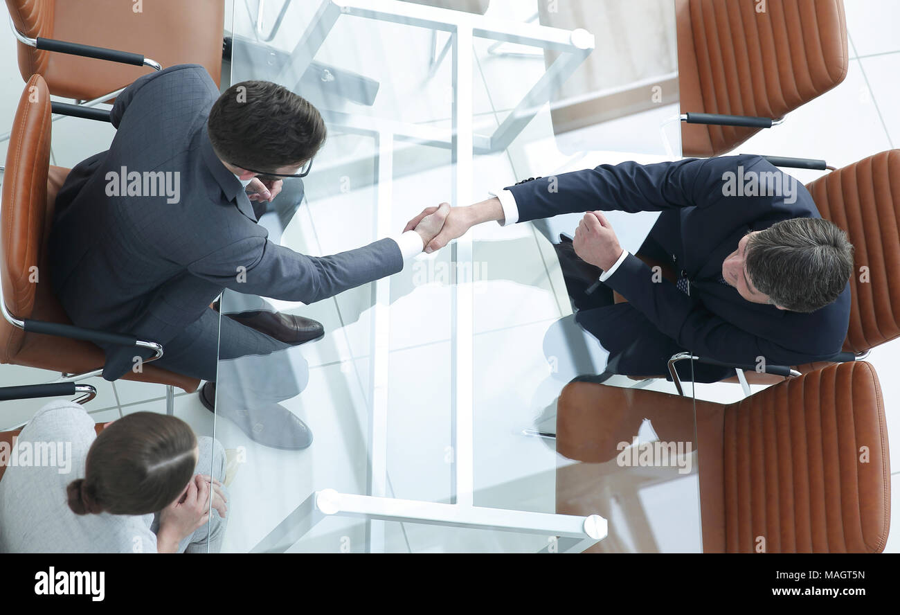 Handshake across the table. Meeting around a boardroom table Stock ...